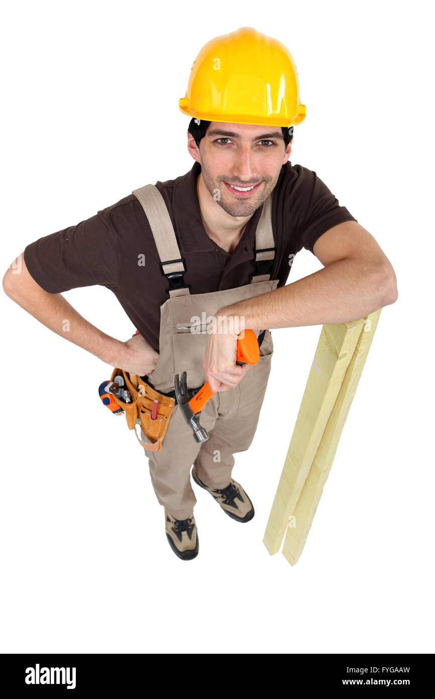 Builder posing with his tools and building supplies Stock Photo - Alamy