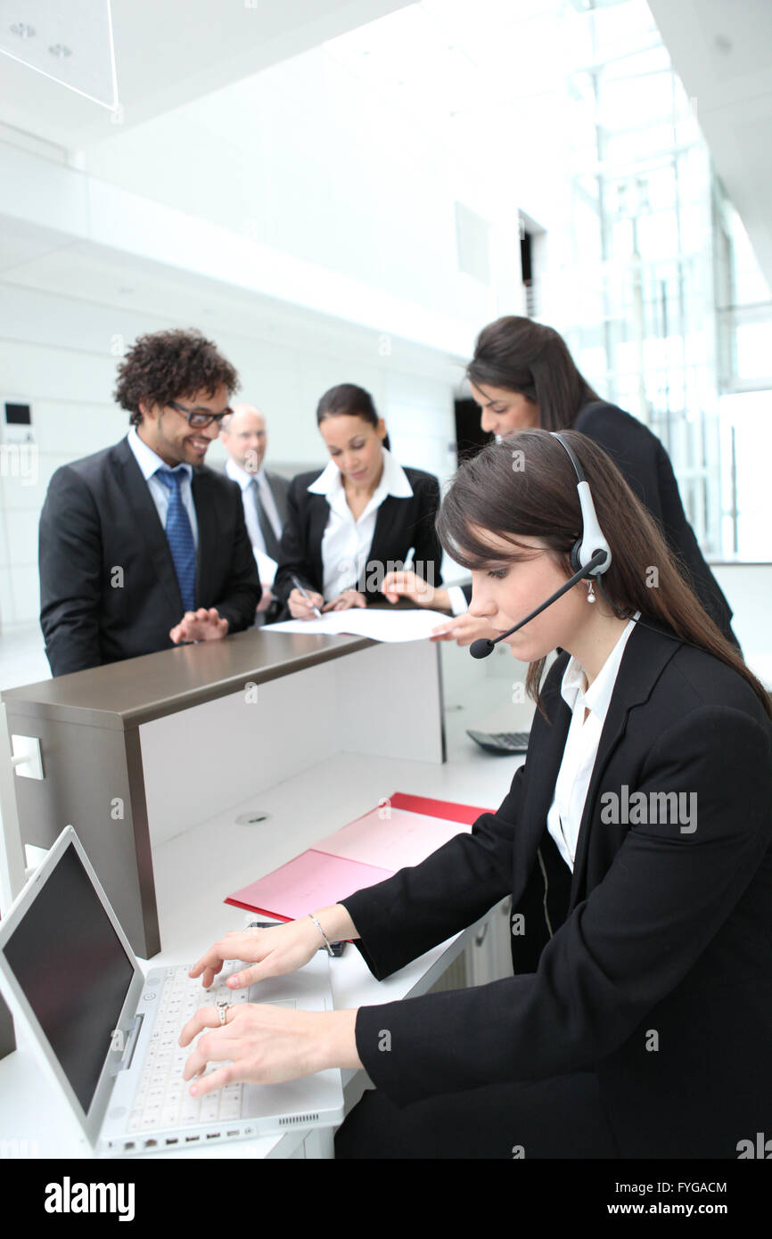 Female receptionist using a headset and laptop computer Stock Photo - Alamy