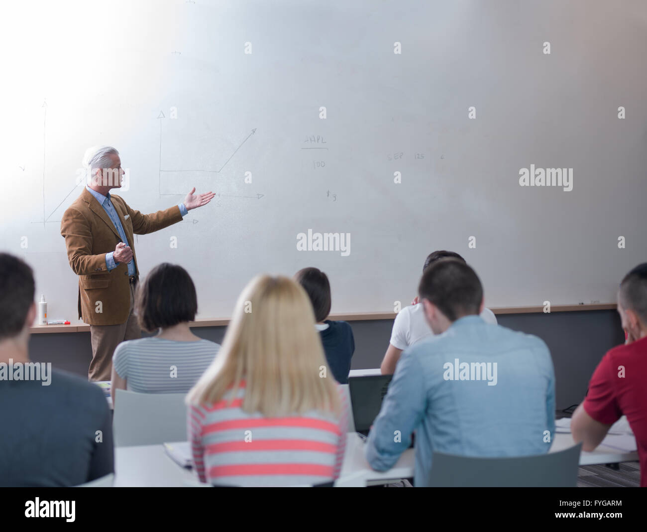 senior teacher with group of happy students in modern school classroom ...