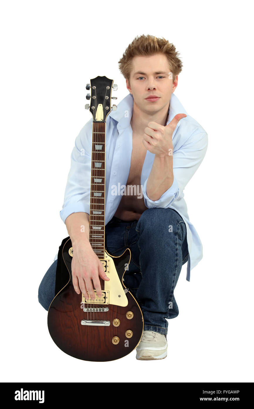 Young man posing with his guitar and giving the thumb's up Stock Photo ...