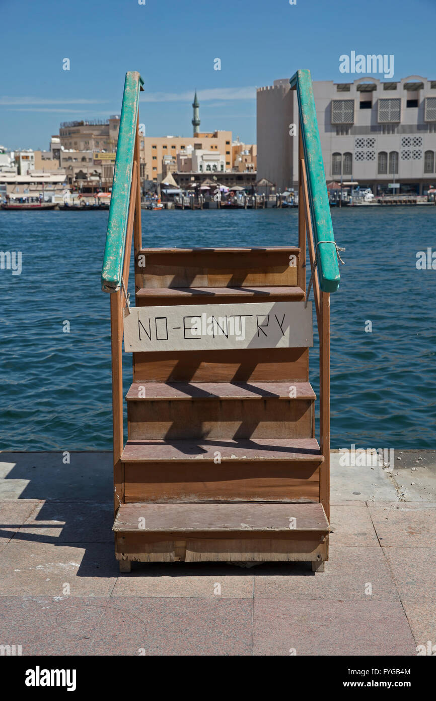 Wooden steps with a No Entry sign by the creek edge in Dubai UAE Stock ...