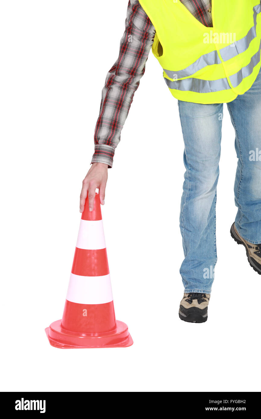Construction worker putting a traffic cone on the floor Stock Photo - Alamy