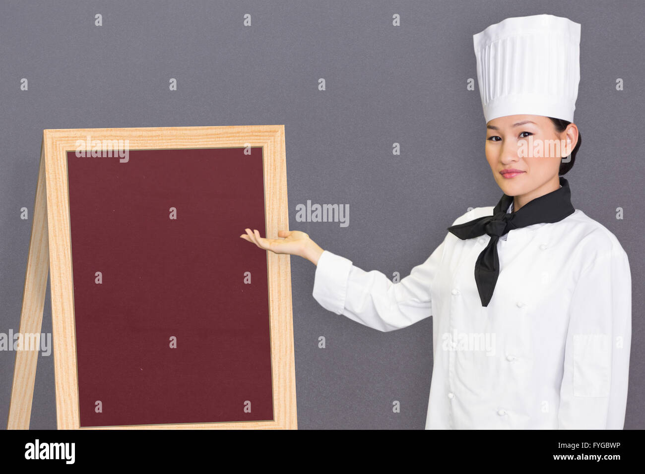 Composite image of confident female cook in the kitchen Stock Photo - Alamy