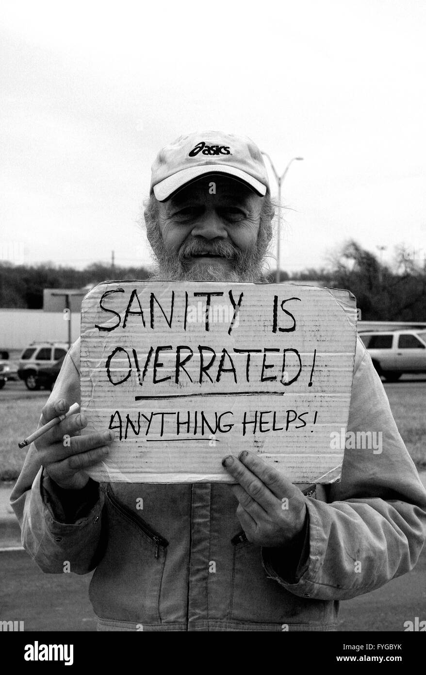 Homeless man asking for change holding a sign that says "Sanity Is ...