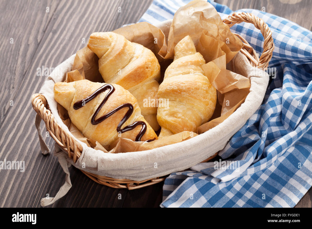 Fresh croissants basket on wooden table Stock Photo - Alamy