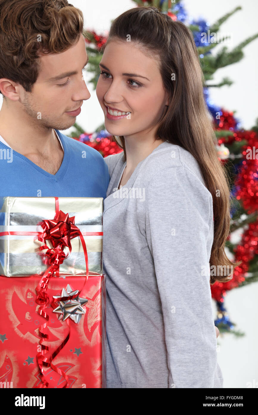 Young man offering gift to his girlfriend for Christmas Stock Photo - Alamy