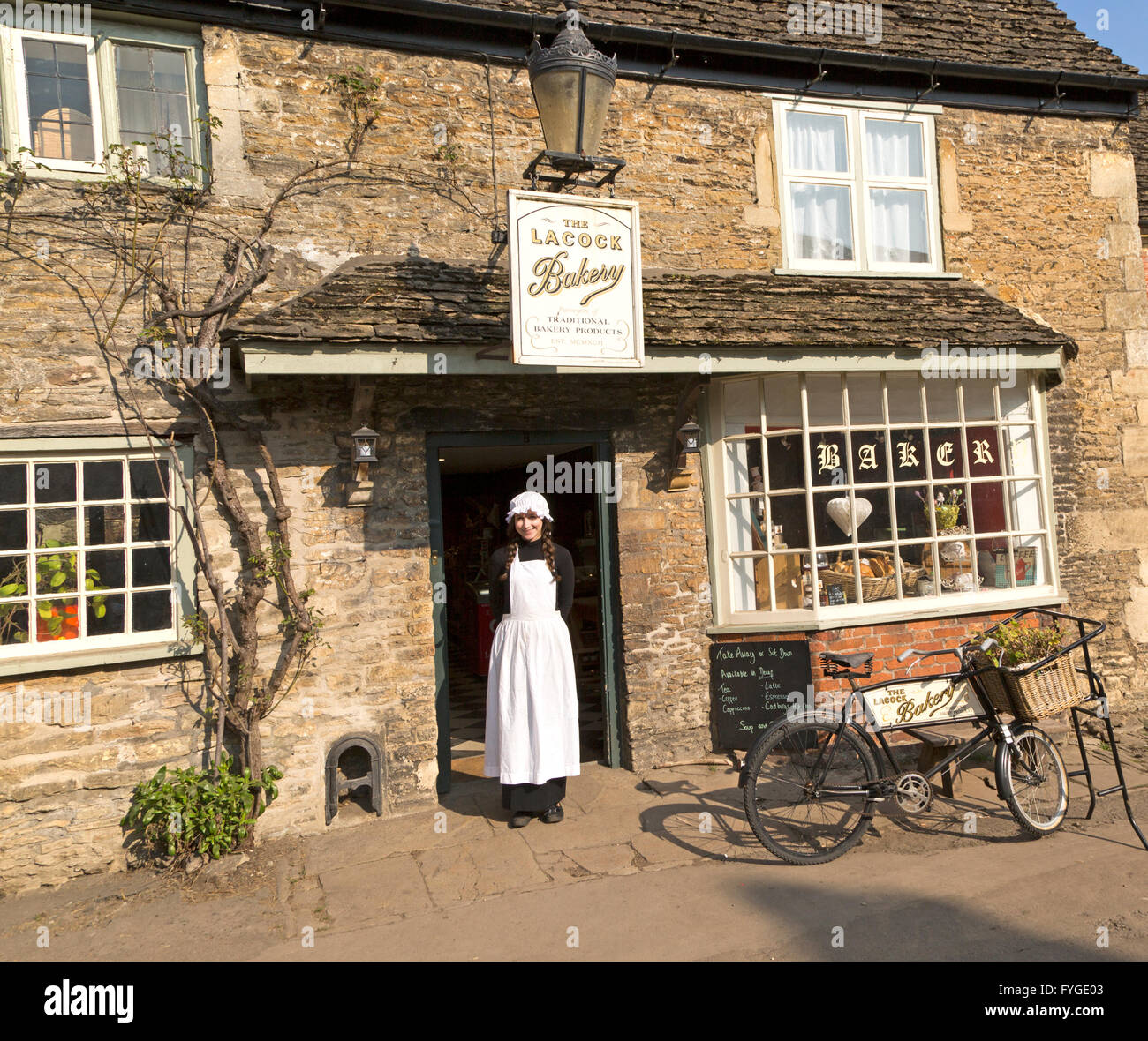 Young shopkeeper woman in old fashioned traditional clothing outside ...