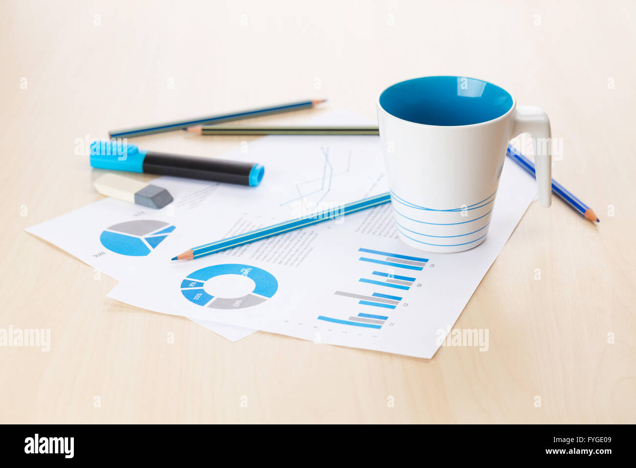 Office workplace with coffee cup and charts on wooden desk table Stock ...