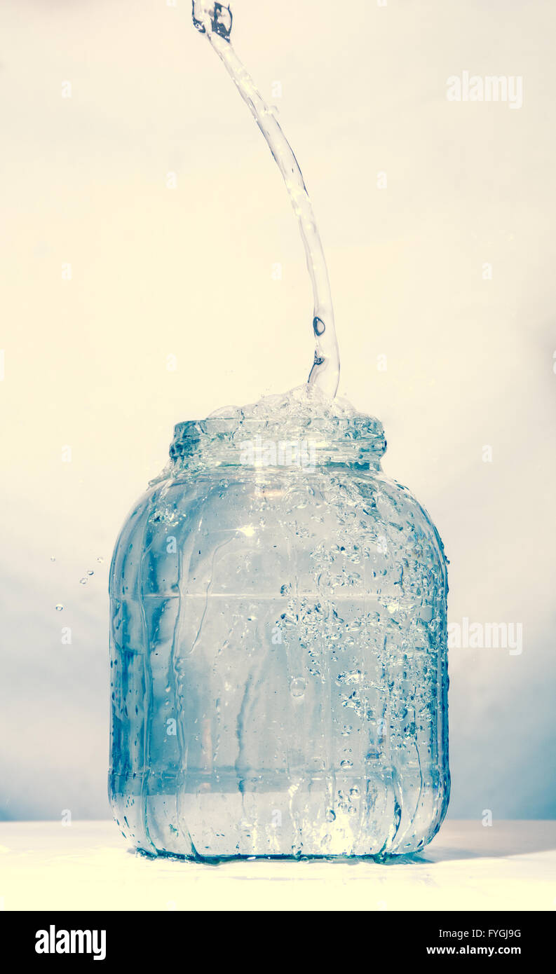Movement of water pouring into a flooded glass recipient Stock Photo ...