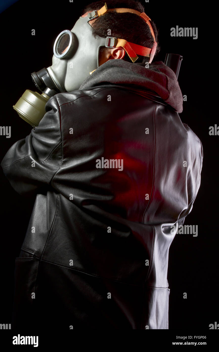 Man with gas mask and gun, dressed in black leather jacket Stock Photo ...
