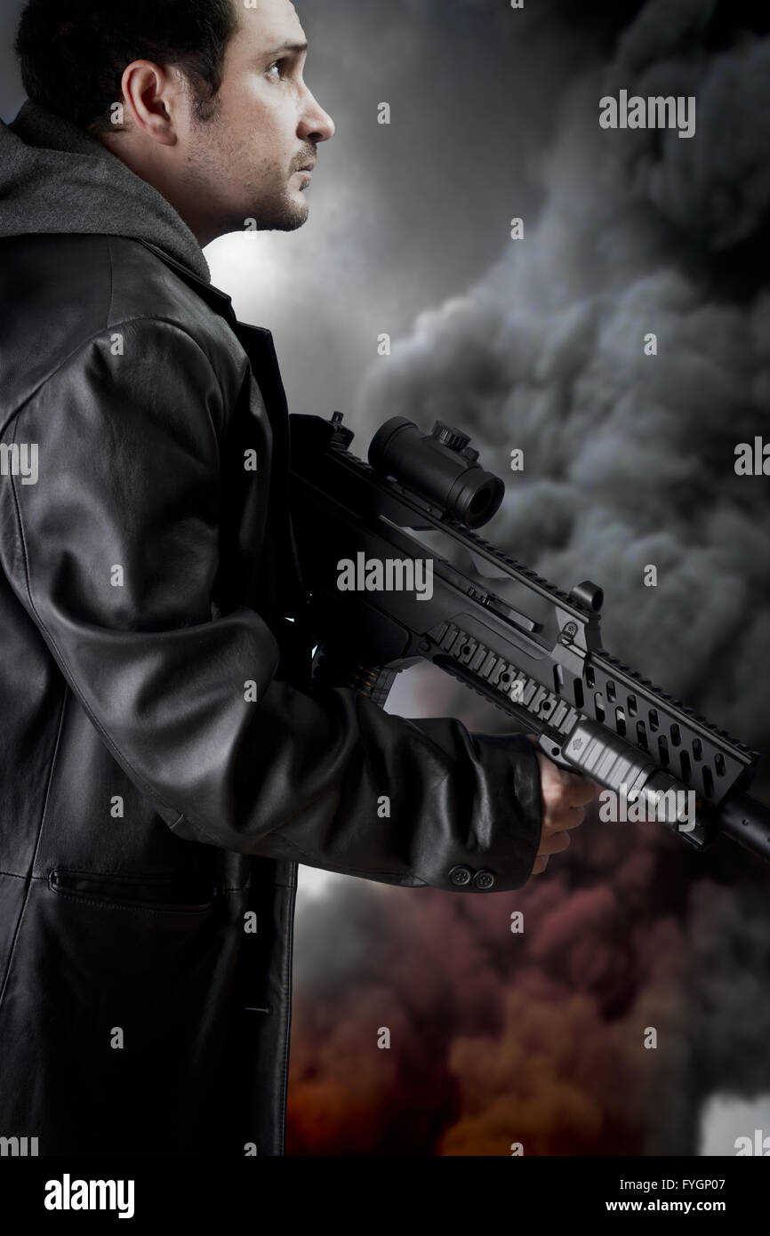 Man with long leather jacket and assault rifle, black smoke background ...