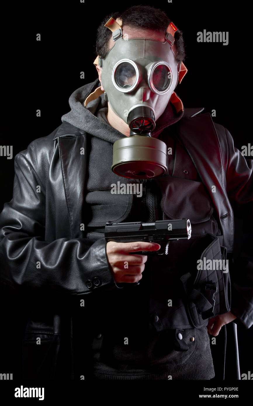 Man with gas mask and gun, dressed in black leather jacket Stock Photo ...