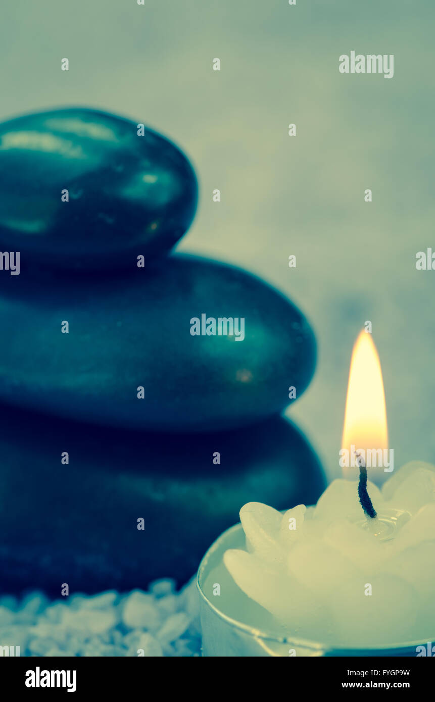 pile of black lava stones and burning candle Stock Photo - Alamy