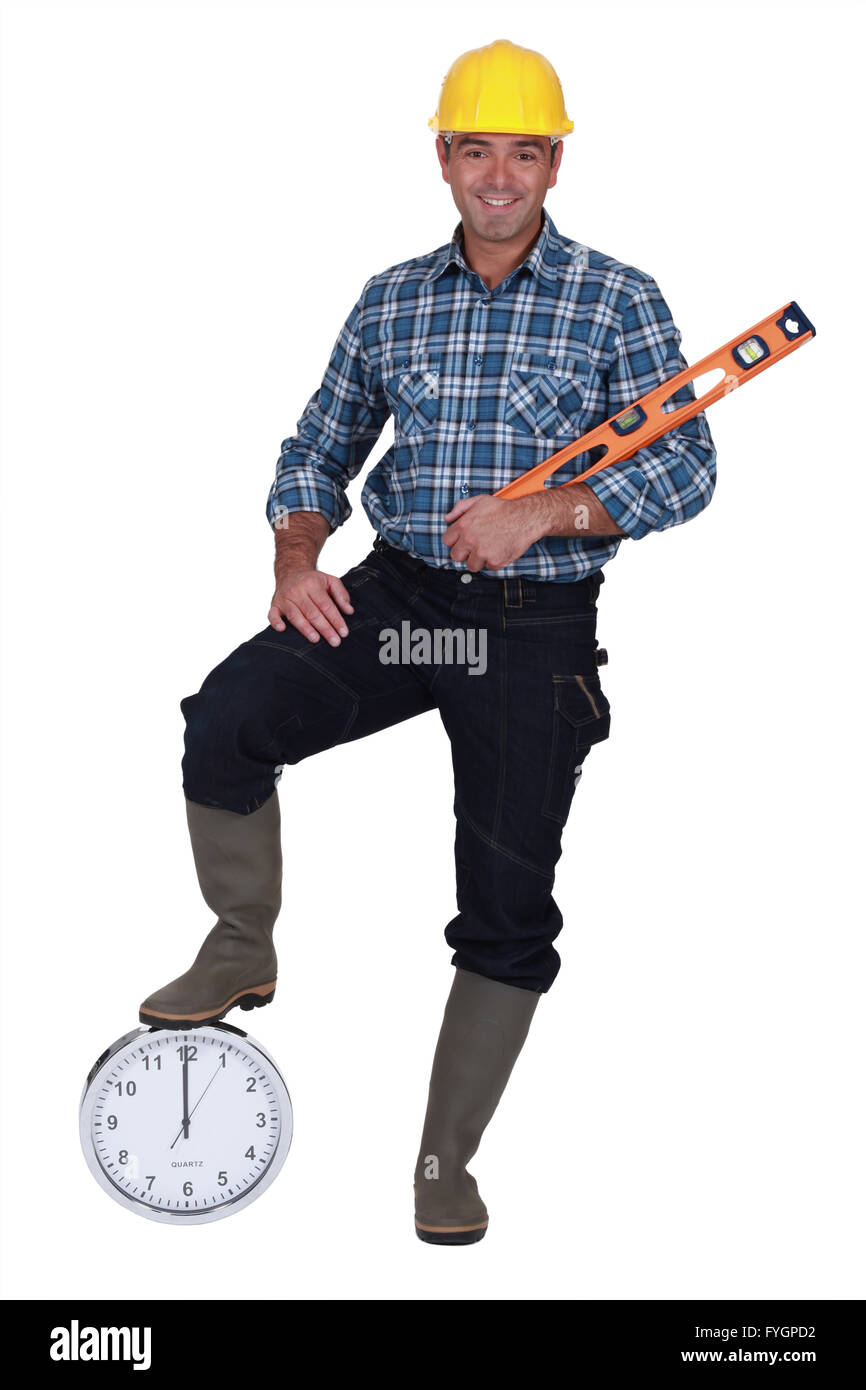 Construction worker holding a bubble level and a clock Stock Photo - Alamy