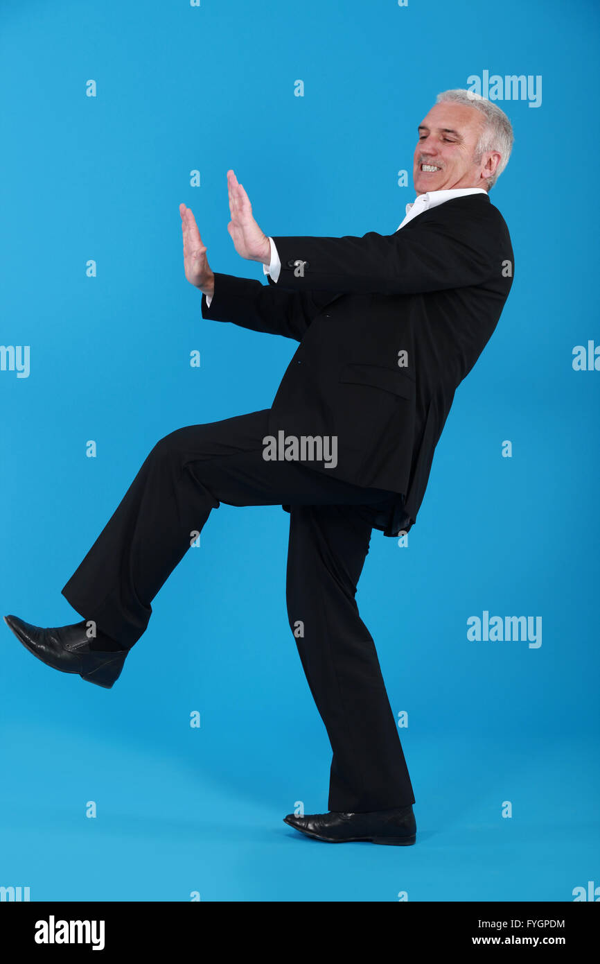 middle-aged man in suit pushing invisible furniture Stock Photo - Alamy