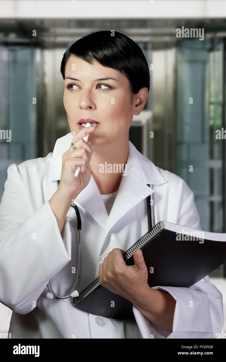Thinking medical doctor with stethoscope. Over hospital background ...