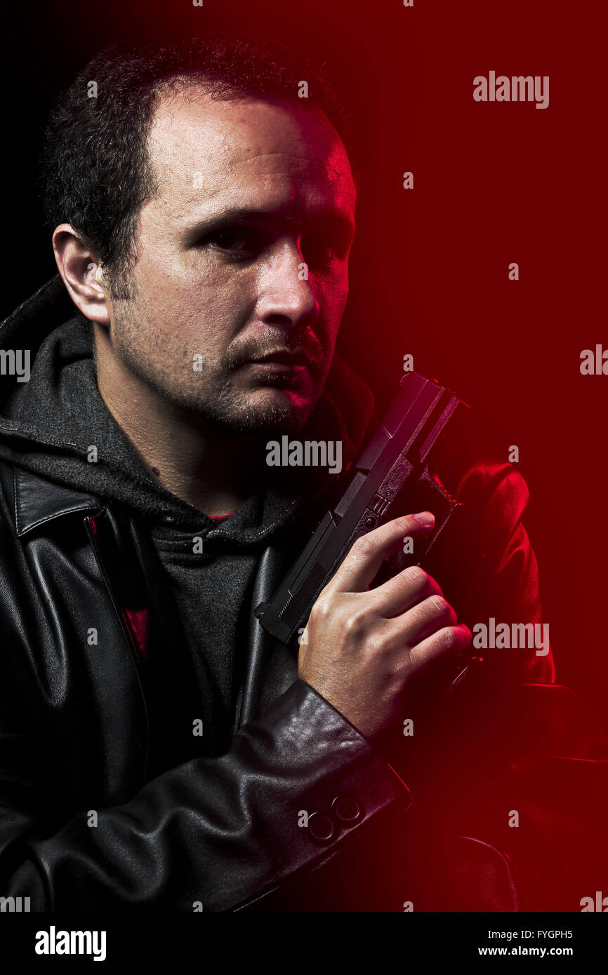 Robber with gun over red background Stock Photo - Alamy