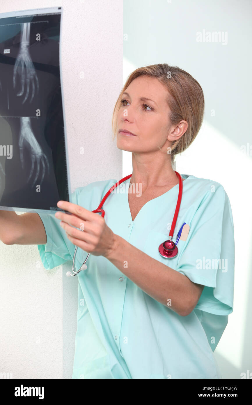Woman in scrubs with stethoscope and clipboard Stock Photo - Alamy
