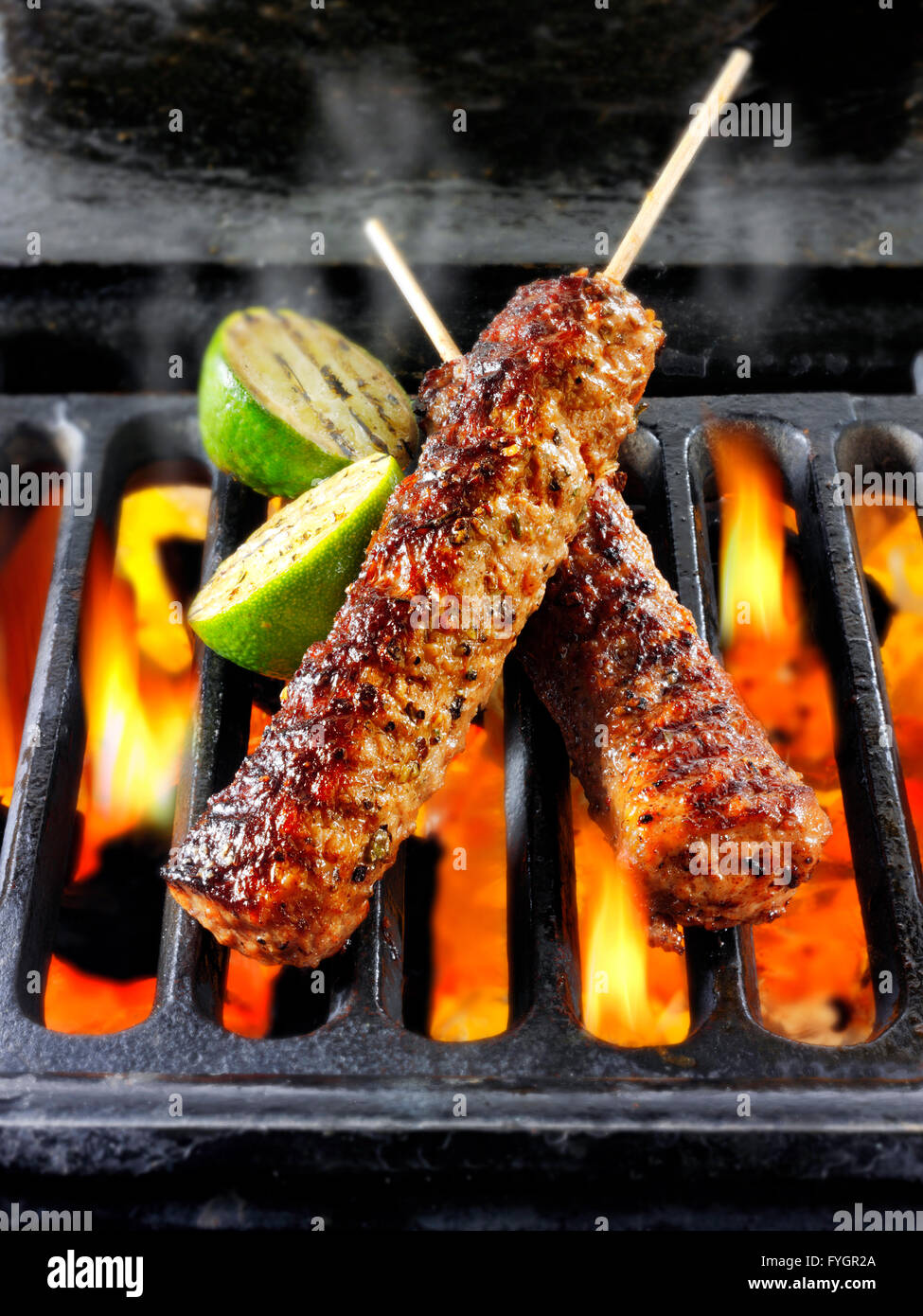BBQ ( barbecue ) kofte kebabs being cooked over open flames of hot ...