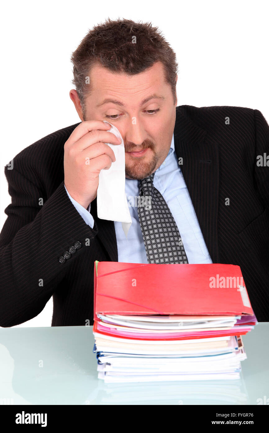 Businessman crying in front of stack of folders Stock Photo - Alamy