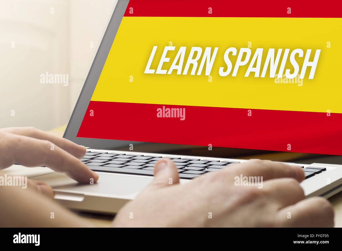 online business concept: man using a laptop with learn spanish on the ...