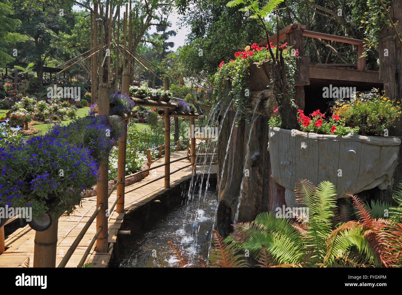 Bamboo path between the fountain and flower beds Stock Photo - Alamy