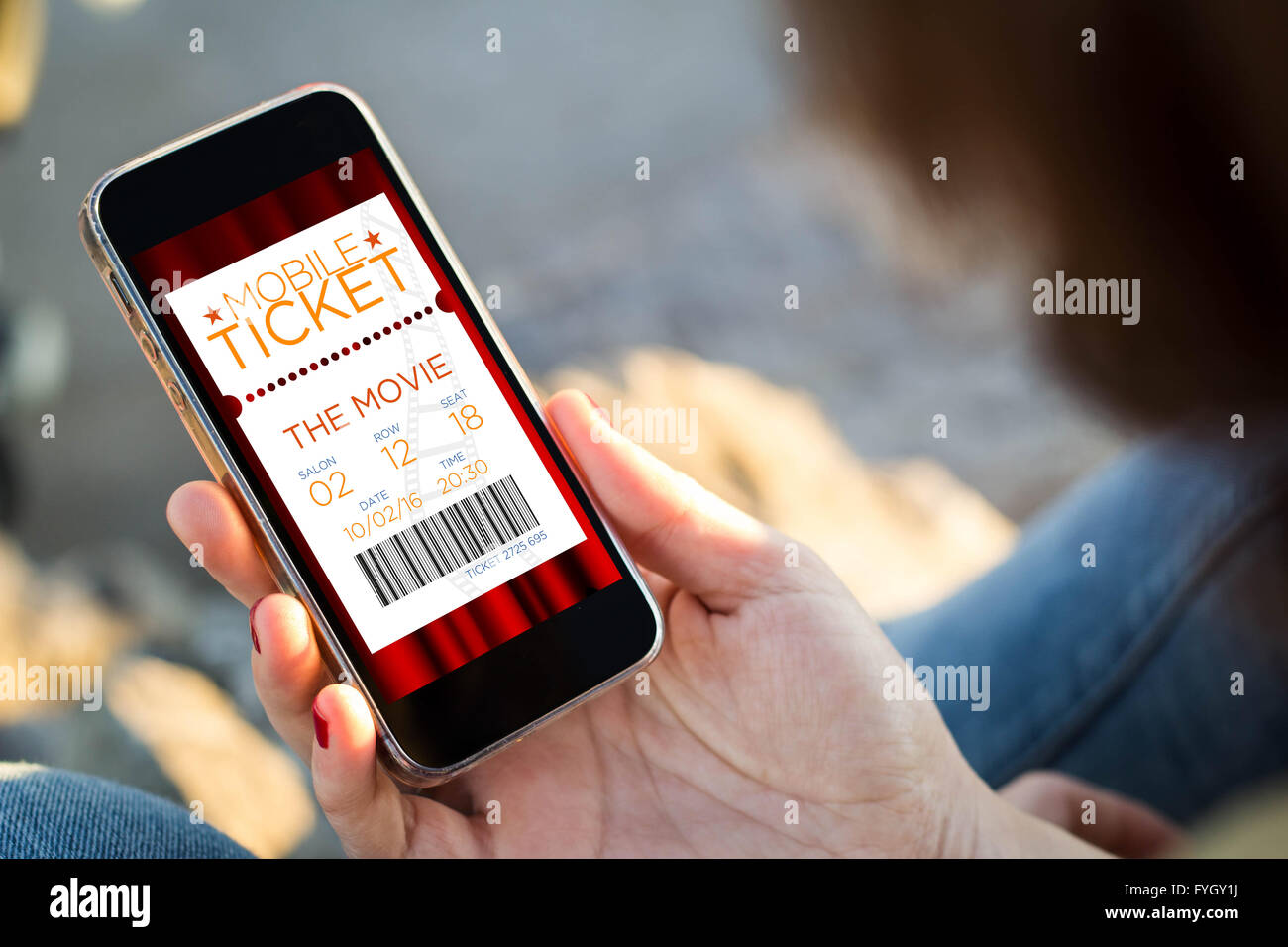 close-up view of young woman buying cinema tickets with a phone. All ...