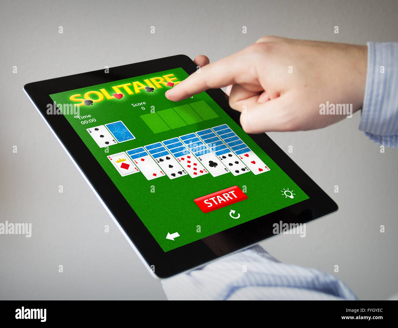 hands with touchscreen tablet with solitaire app. All graphics are made ...