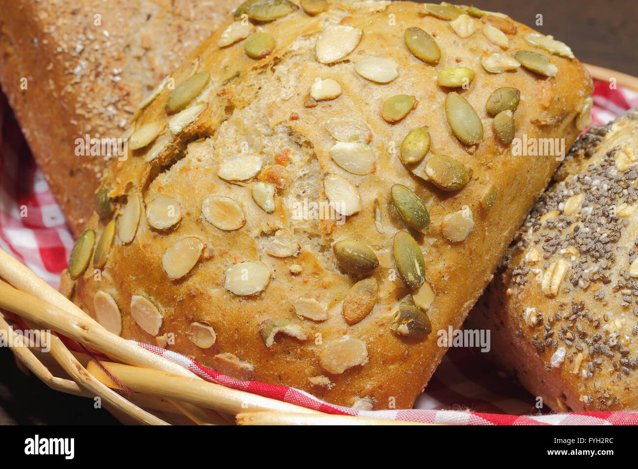Various types of bread rolls, cakes, bun, in a basket, on a rustic ...