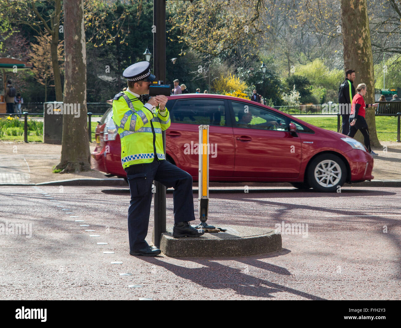 A policeman checks for speeding cars on the Mall in central London ...
