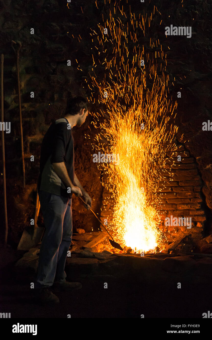 Blacksmith working in the fireplace of an old forge Stock Photo - Alamy