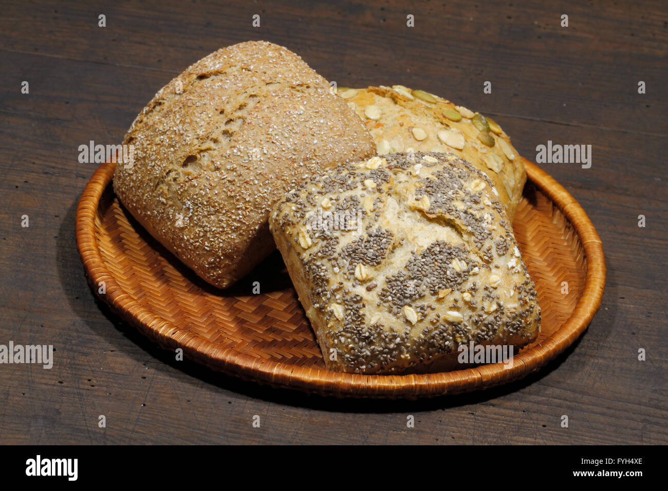 Various types of bread rolls, cakes, bun, in a basket, on a rustic ...