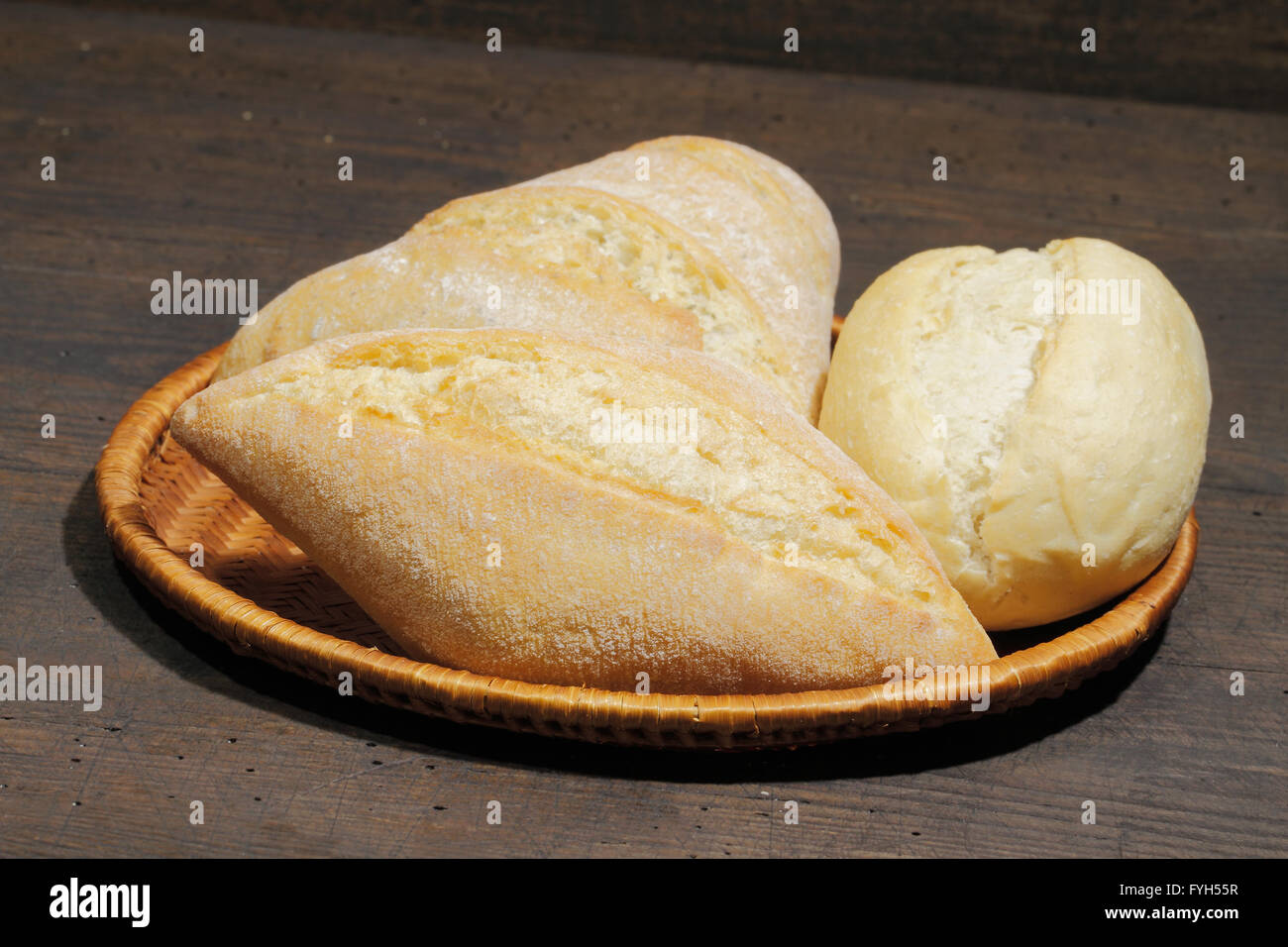 Various types of bread rolls, cakes, bun, in a basket, on a rustic ...