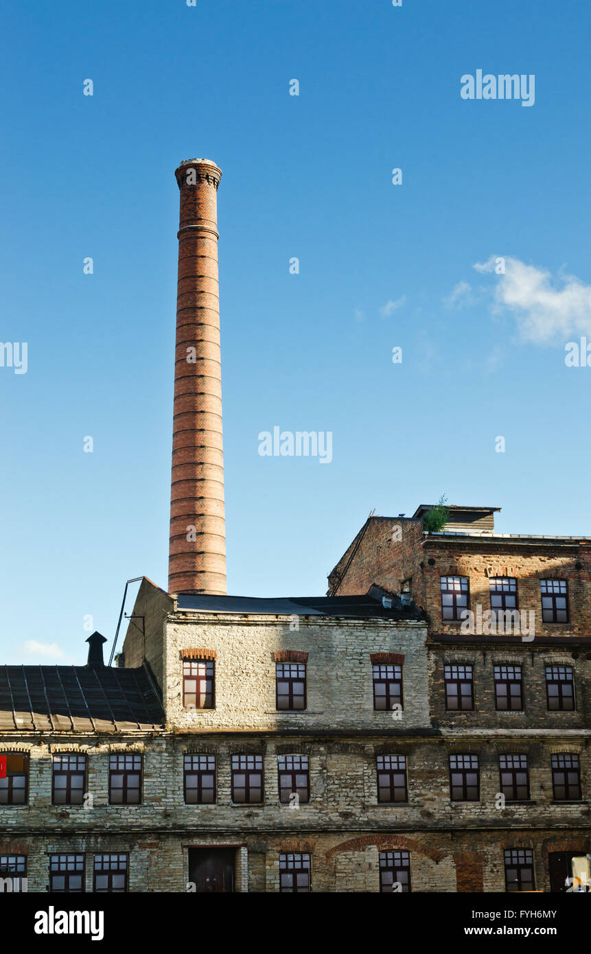 Smokestack towers over the old industrial building Stock Photo - Alamy
