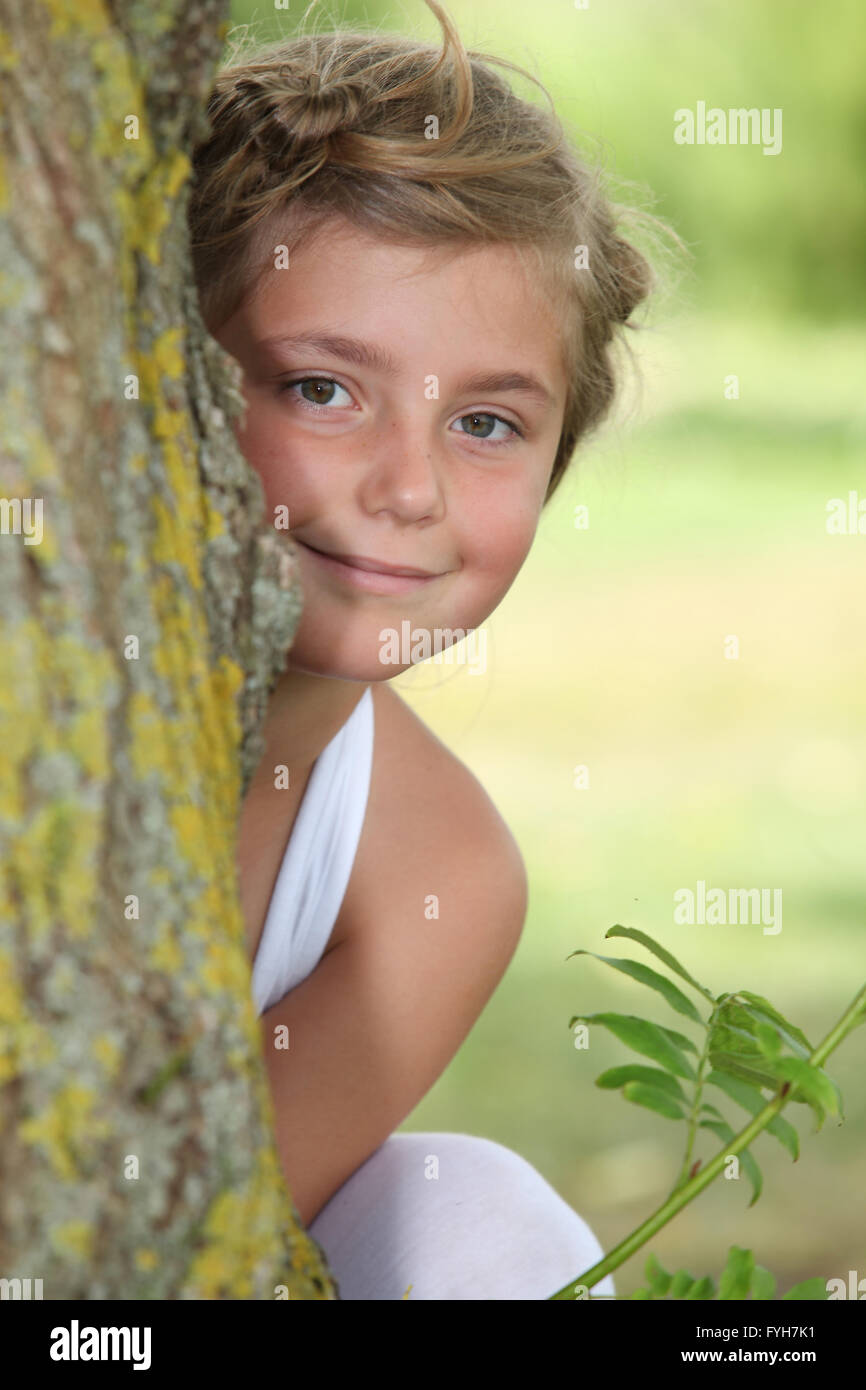 Girl behind tree hi-res stock photography and images - Alamy