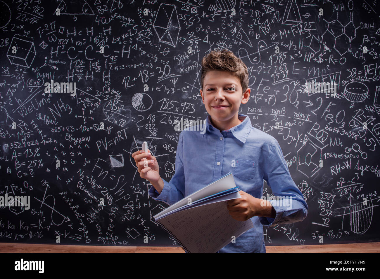 Boy holding notebook and chalk, big blackboard with formulas Stock ...