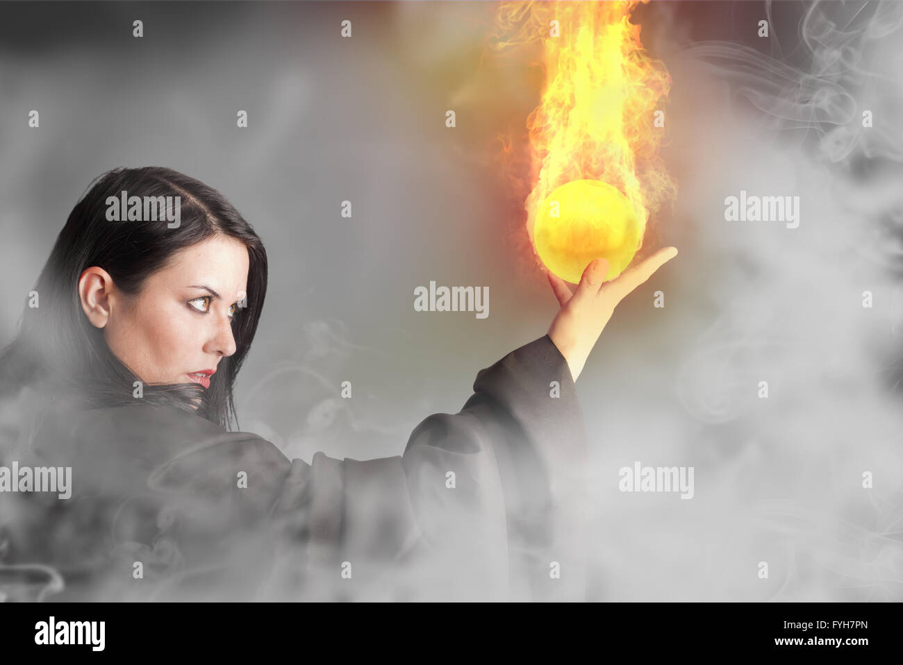 Magician woman with a fire ball in her hands Stock Photo - Alamy