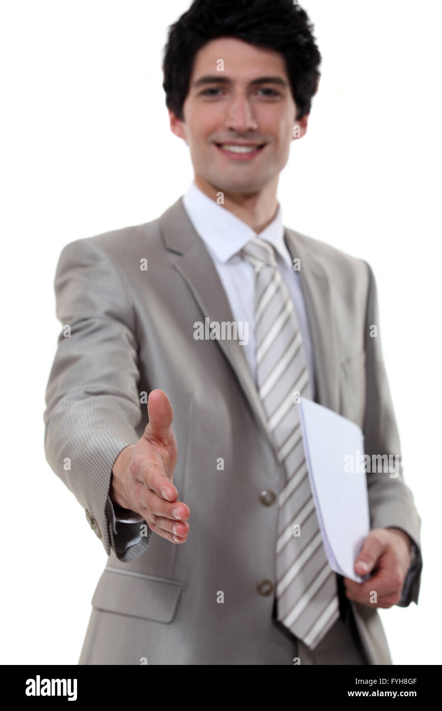 young businessman all smiles shaking hands with invisible ...