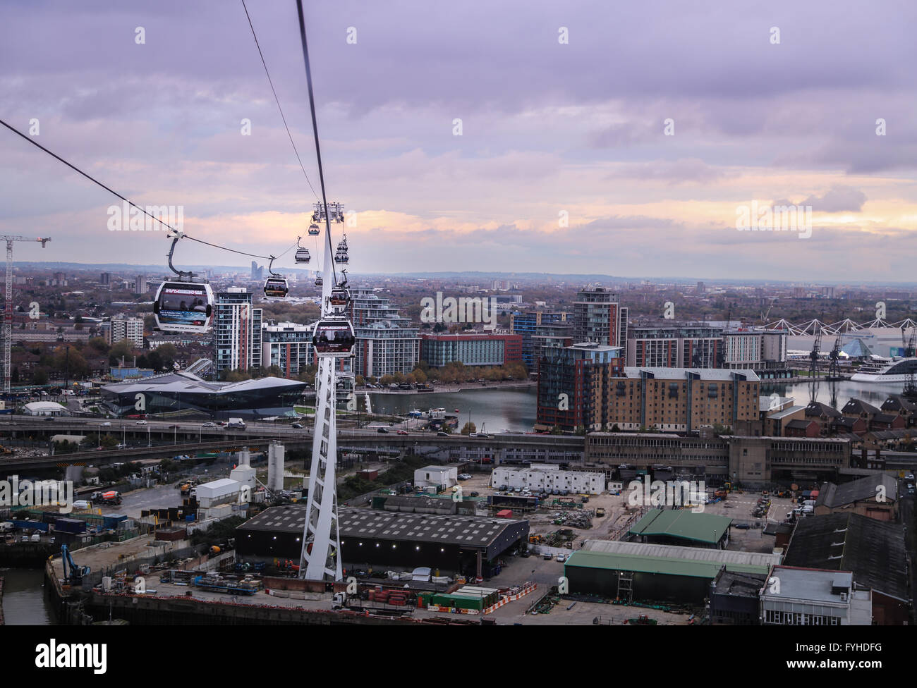 The Emirates Airline cable car descending at sunset at Canary Wharf ...