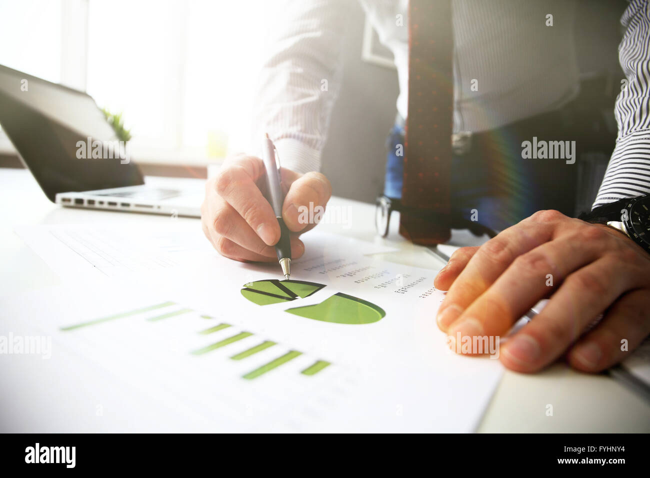 Finger showing point of intersection on financial graph Stock Photo - Alamy