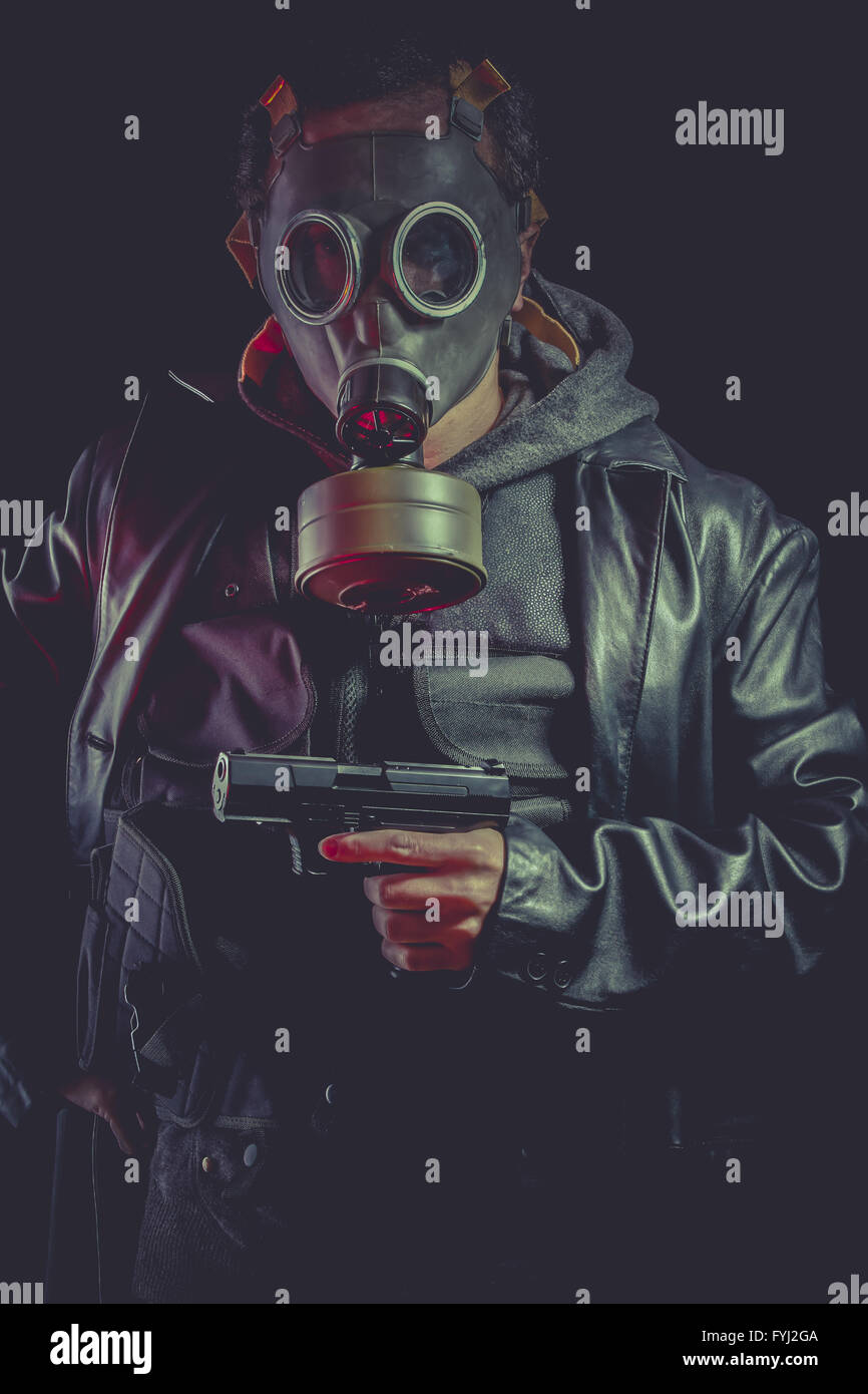 Man with gas mask and gun, dressed in black leather jacket Stock Photo ...