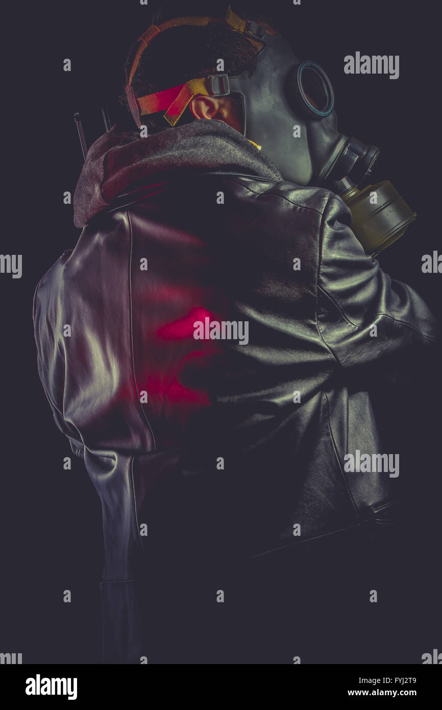Man with gas mask and gun, dressed in black leather jacket Stock Photo ...