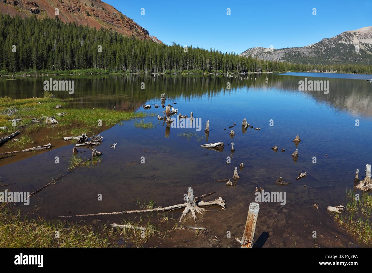 Blue sky reflected in the blue water of a lake hi-res stock photography ...