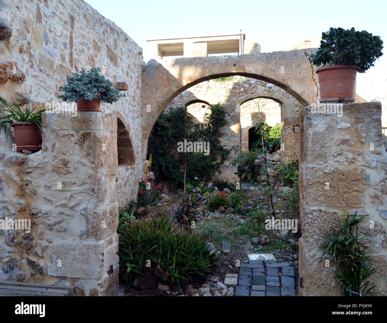 Ruins in stones to transform into garden growing green with flowers and ...