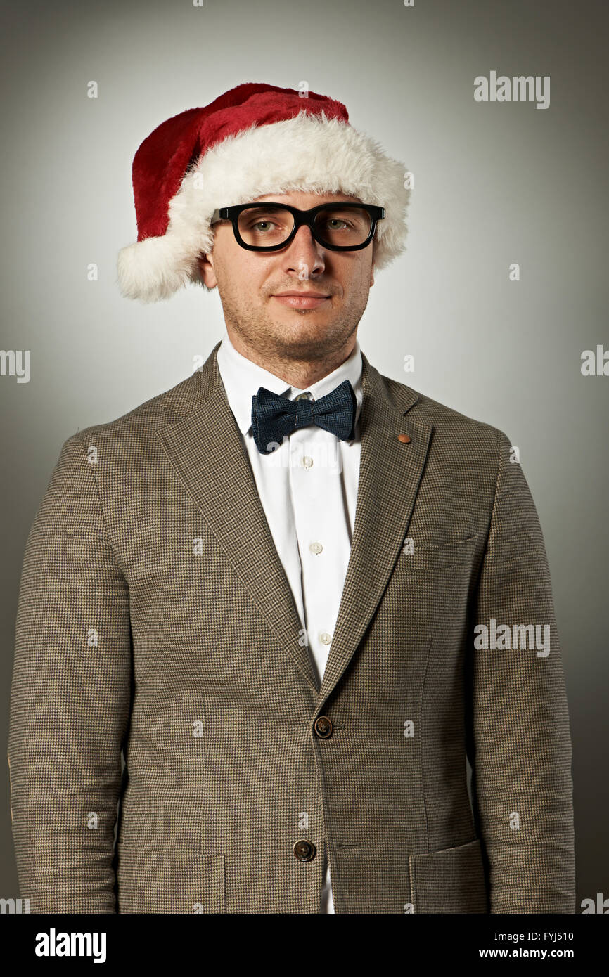Confident nerd in Santa Claus hat and bow tie Stock Photo - Alamy