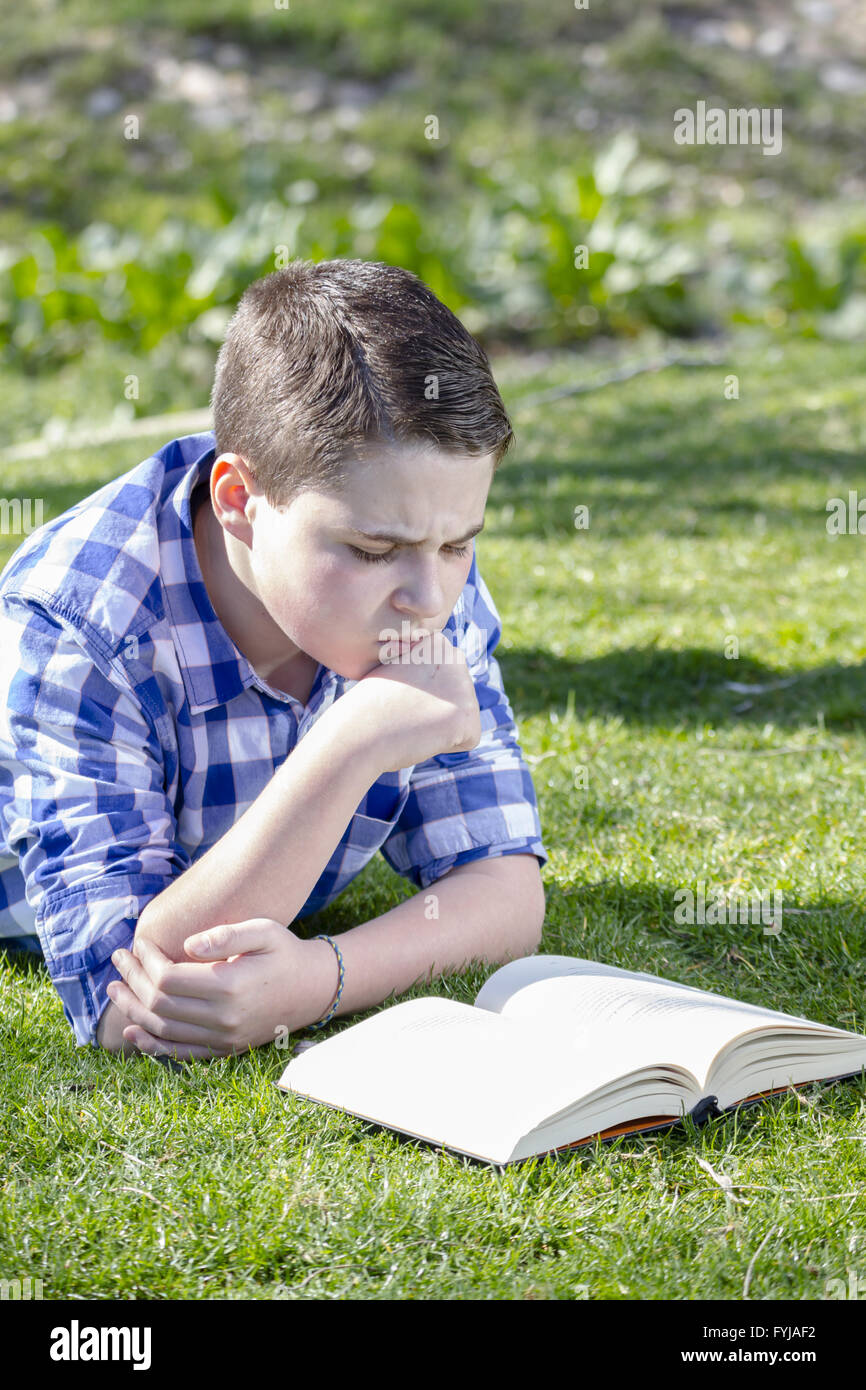 Young boy reading a book in the woods with shallow depth of field and ...