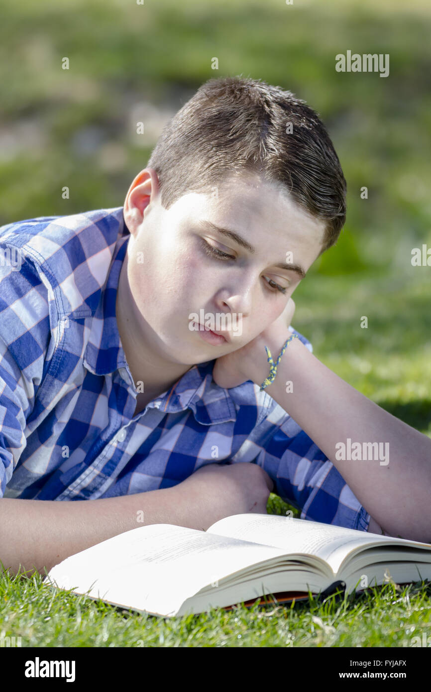 Young boy reading a book in the woods with shallow depth of field and ...