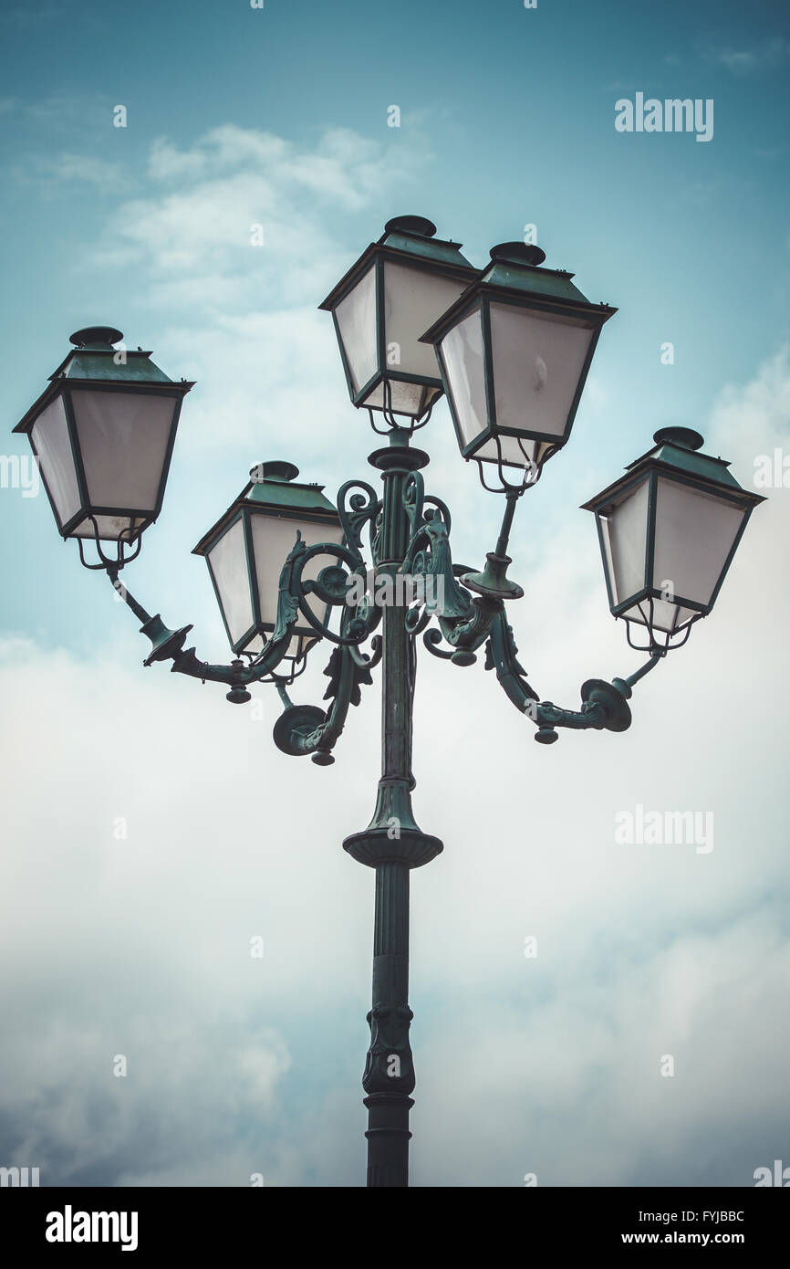 vertical, traditional street lamp with decorative metal flourishes ...