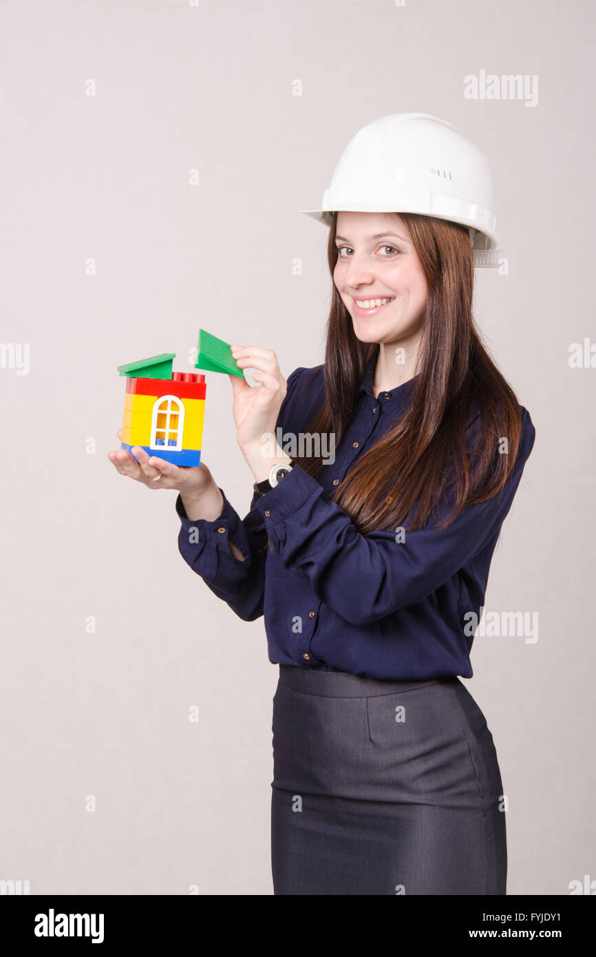 Construction worker stands with a house in the hands of Stock Photo - Alamy