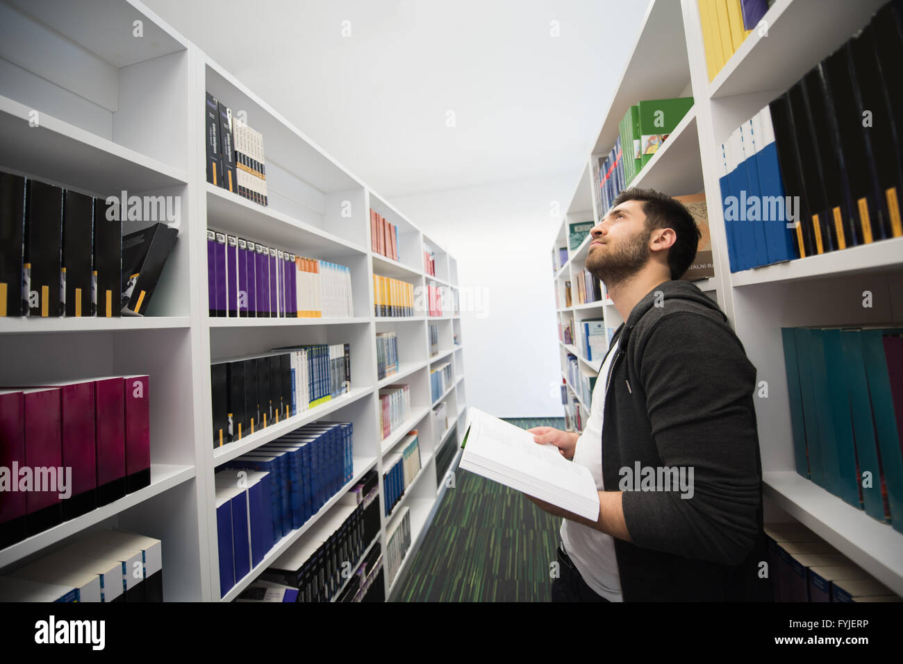 Student reading book in school library. Study lessons for exam. Hard ...